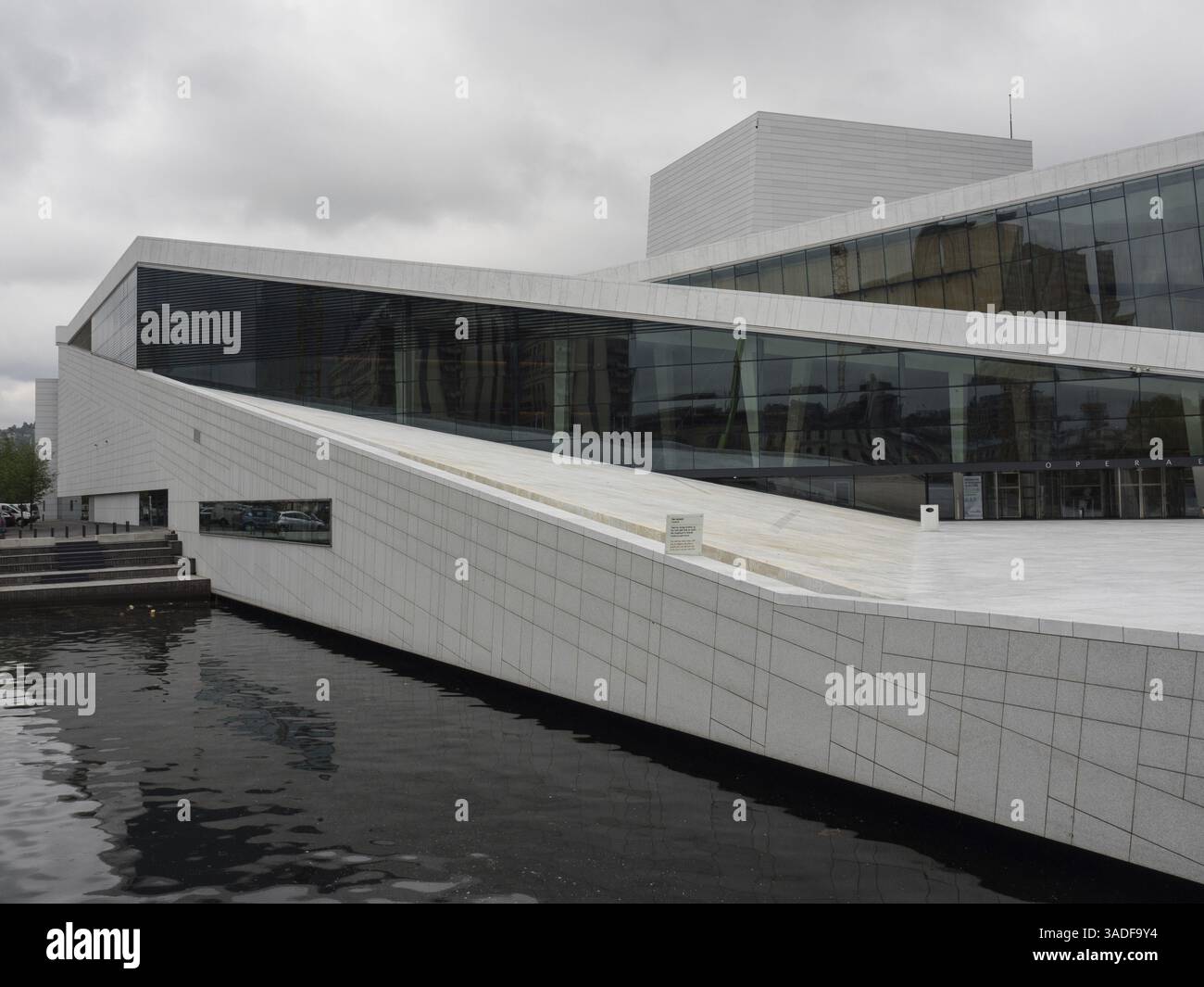 Modern building with glass facades on the waterfront under a grey sky ...