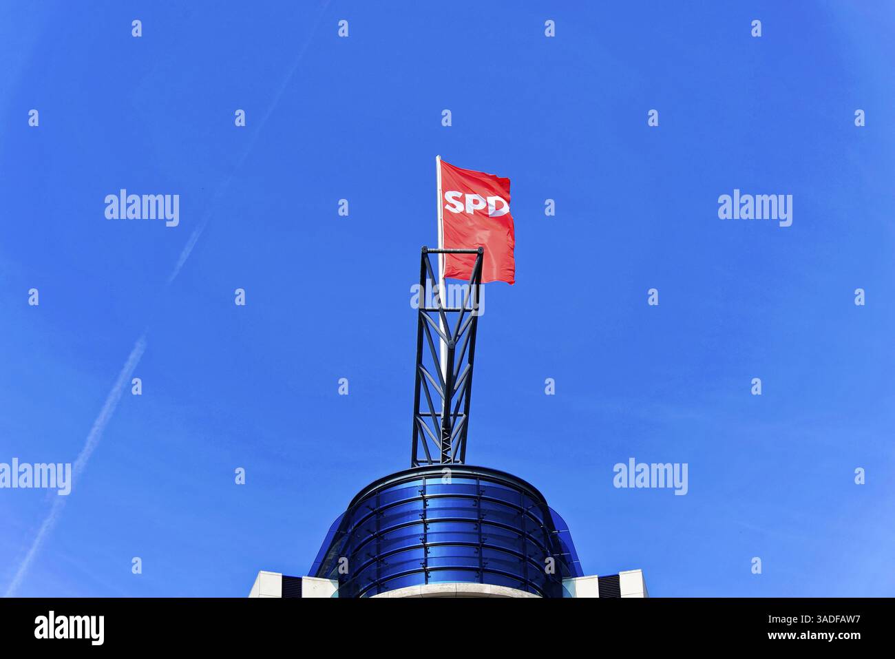A modern office building on a street corner with a flag and autumnal ...