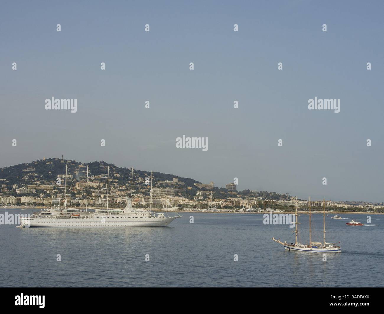Two large ships in front of a coastal town in a calm sea, cannes ...