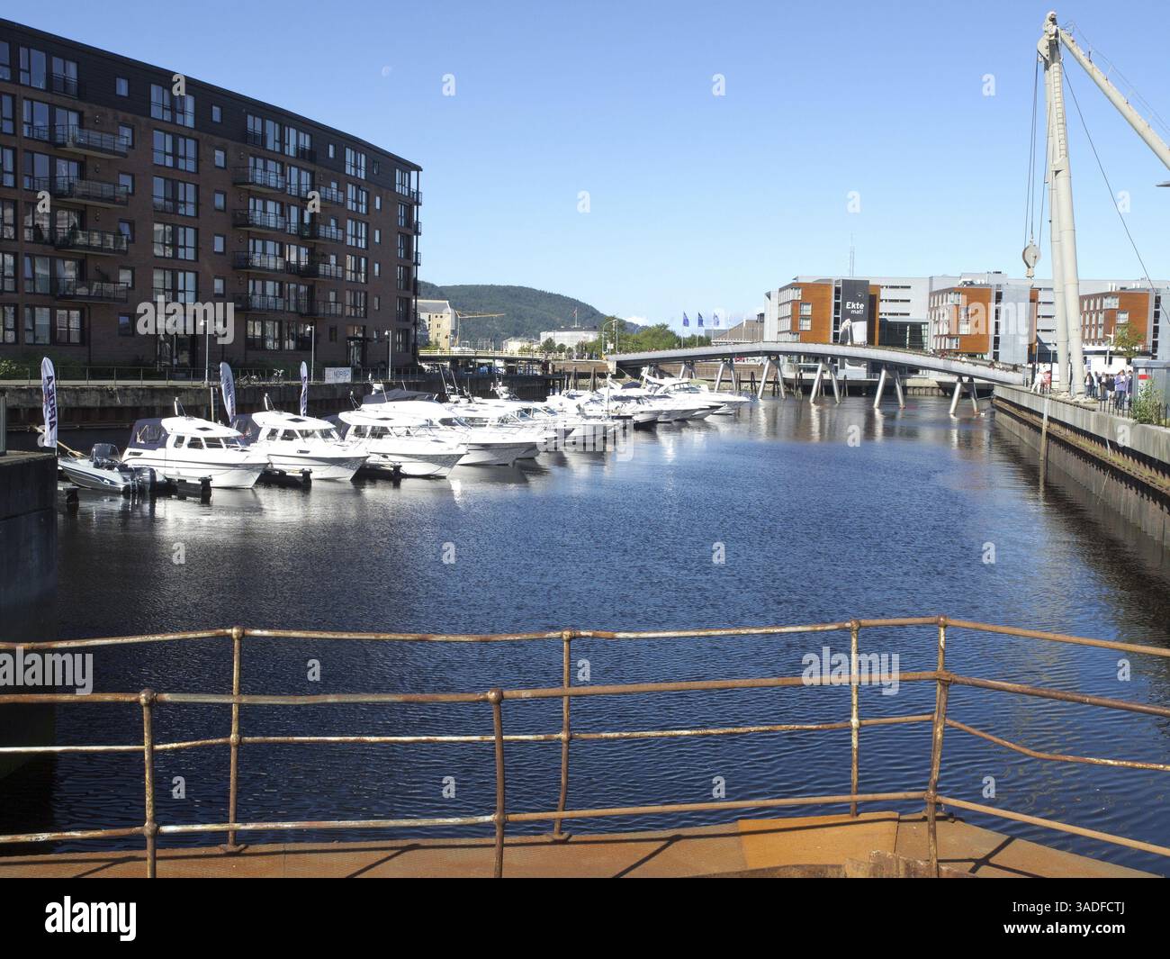 Modern harbour with boats and bridge under a slightly cloudy sky ...