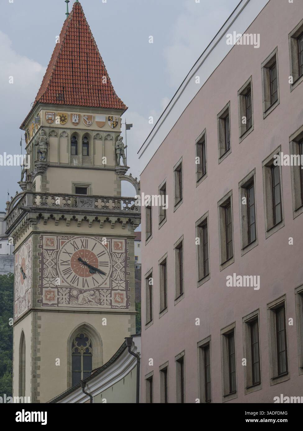Historic clock tower with red tiled roof and decorated clock face in ...