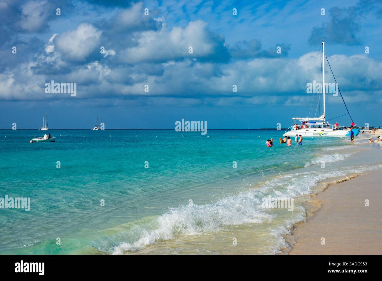 Tourists swim near a catamaran on the turquoise waters of Grace Bay ...