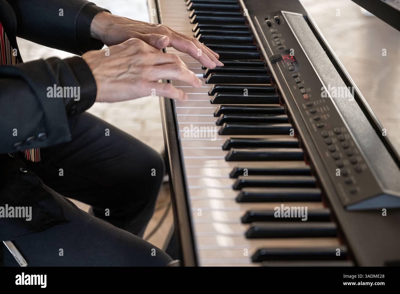Hands of the keyboard player on the black and white keys of the piano ...