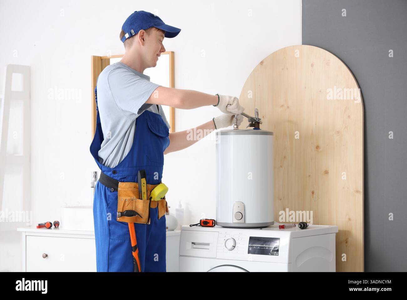 Male technician repairing boiler in bathroom Stock Photo - Alamy