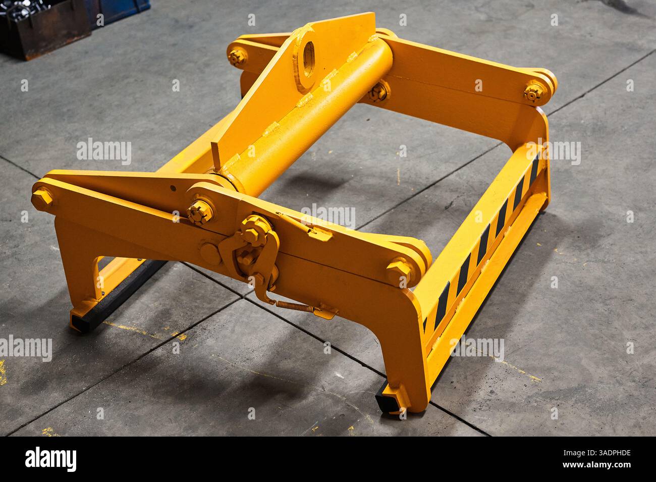 Yellow lifting grab on concrete floor of plant workshop Stock Photo - Alamy