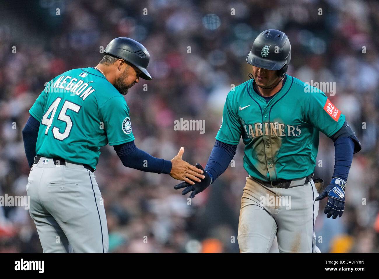 Seattle Mariners' Dylan Moore, right, celebrates with third base coach ...
