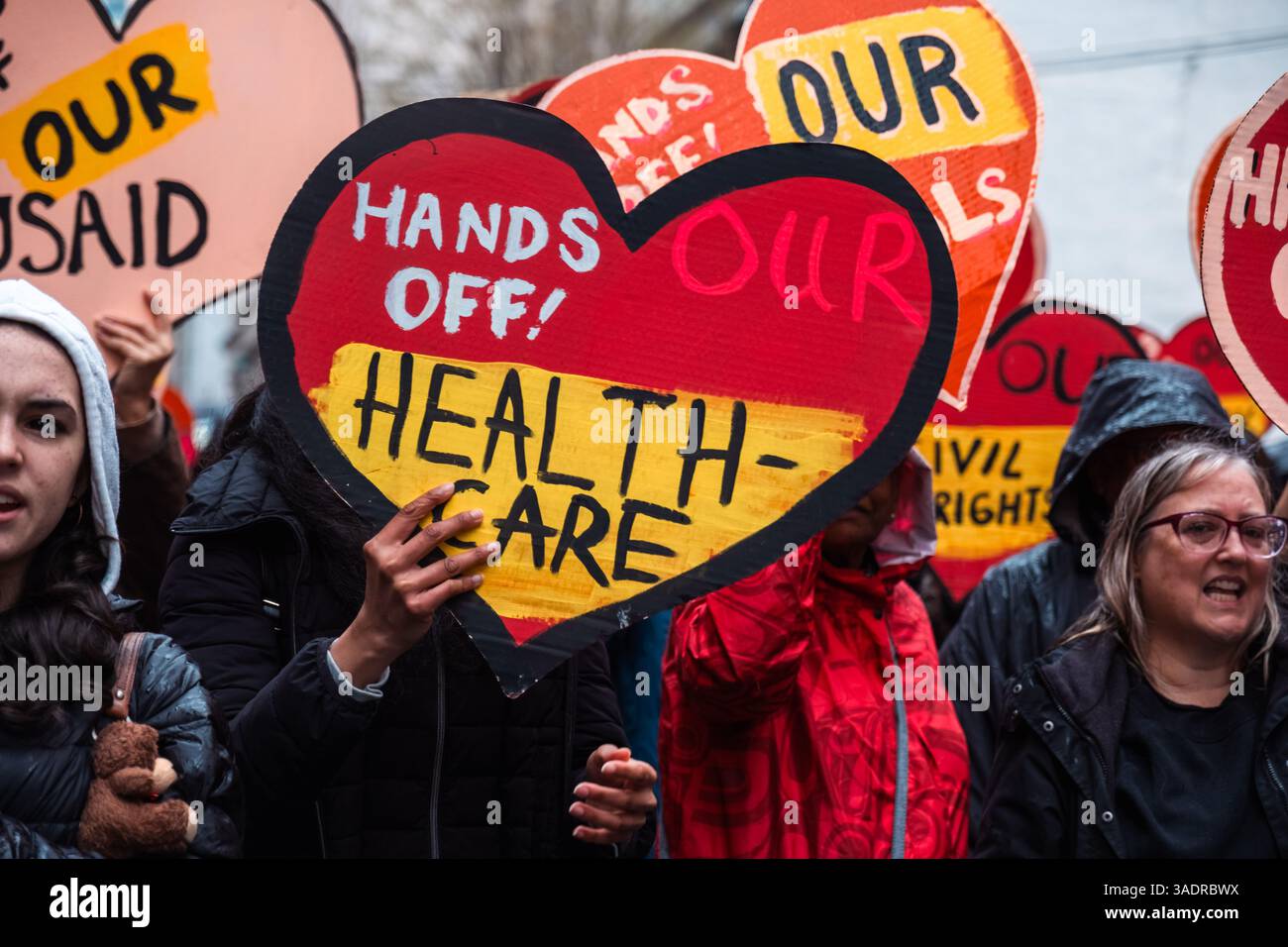 A protester holds a heart that says "hands off our healthcare" during ...