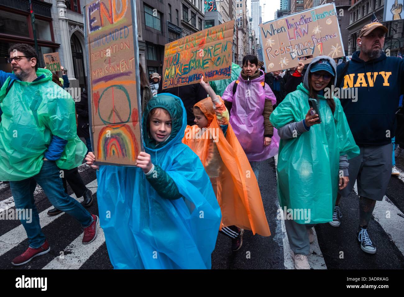 Young kids march in the protest wearing colorful rain ponchos holding ...
