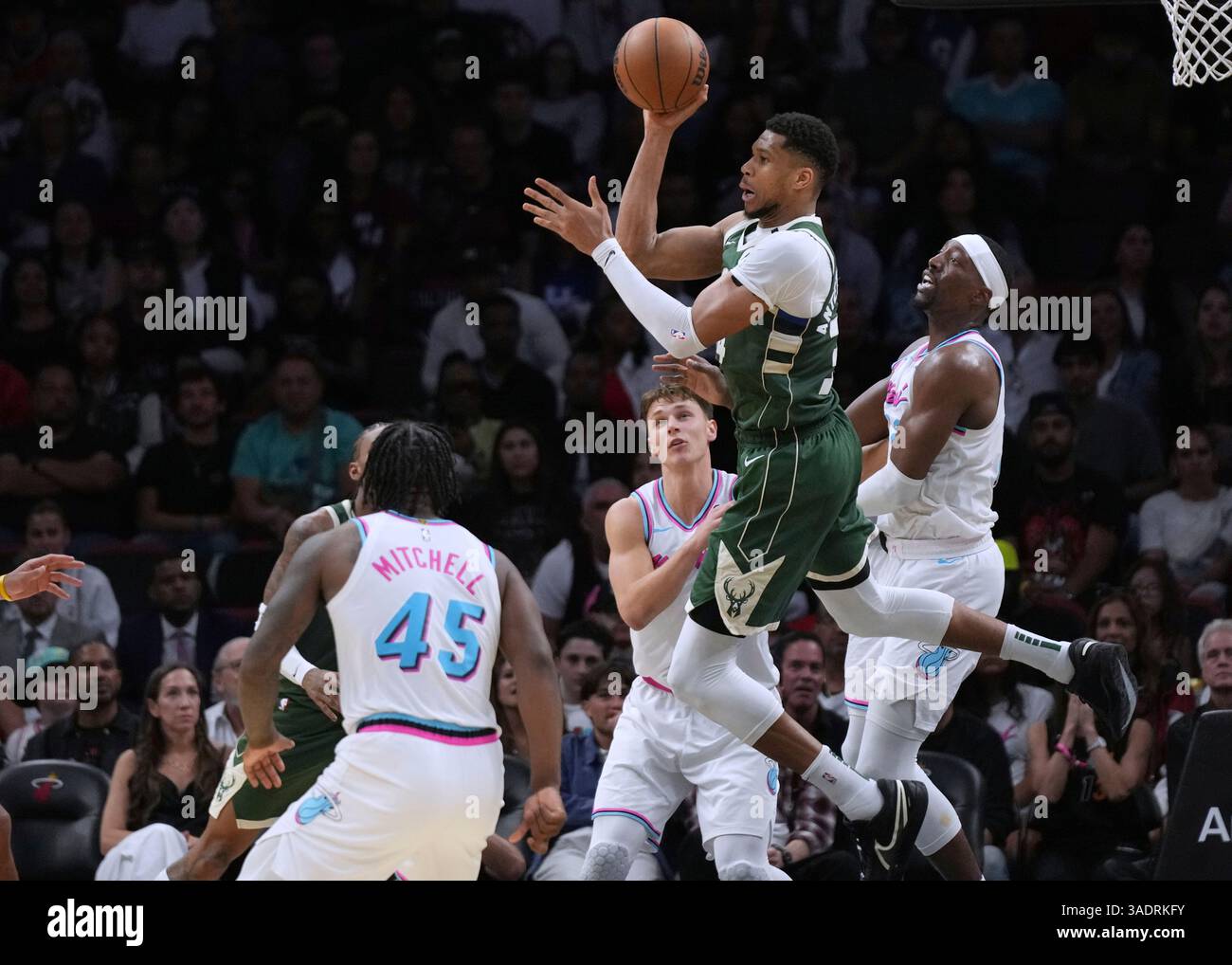 Milwaukee Bucks forward Giannis Antetokounmpo, second from right, passes the ball as Miami Heat ...