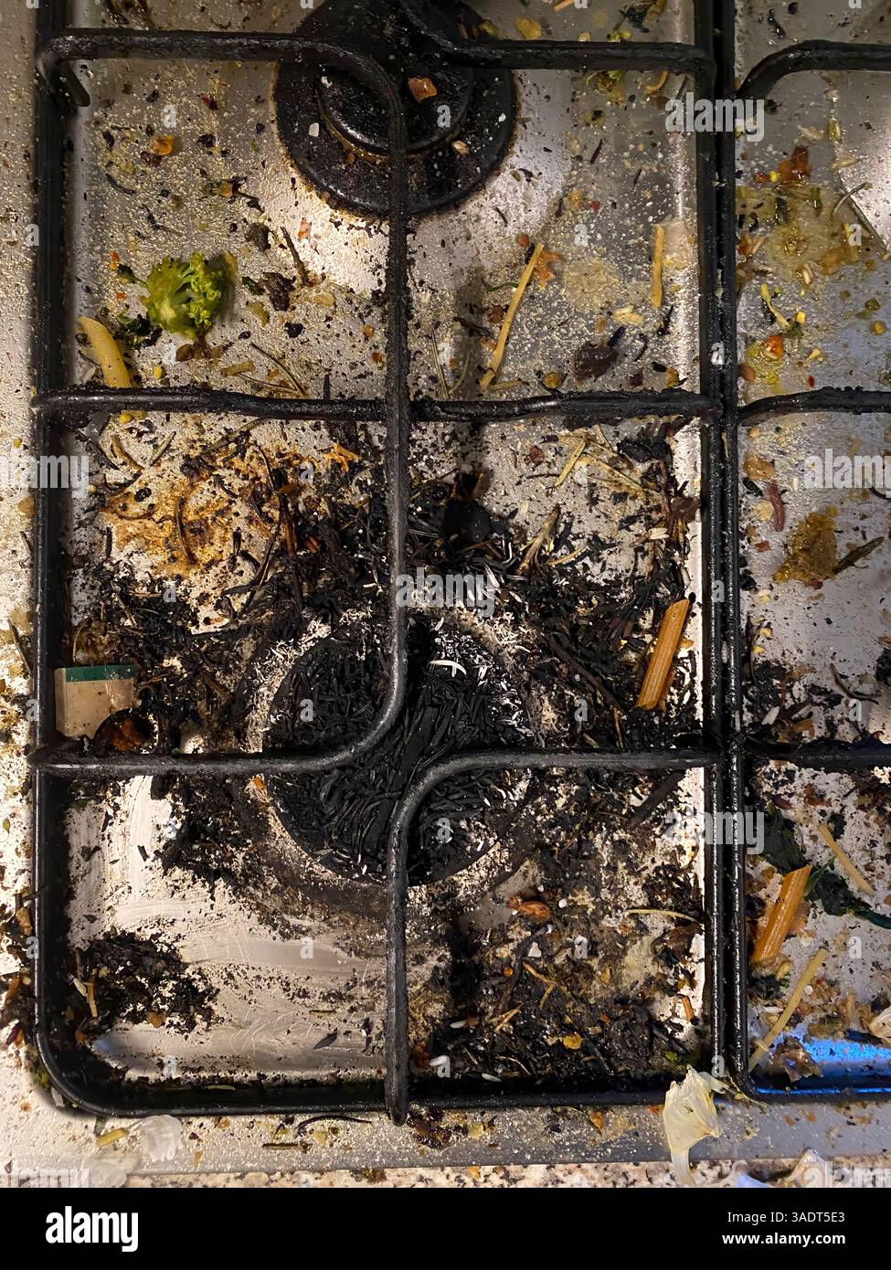 Cremona, Italy March 9th 2025 Very dirty gas stove full of burnt food ...