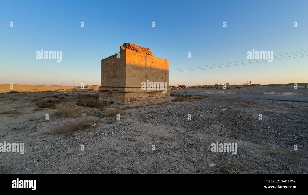 A solitary ancient stone structure stands in a barren desert landscape ...