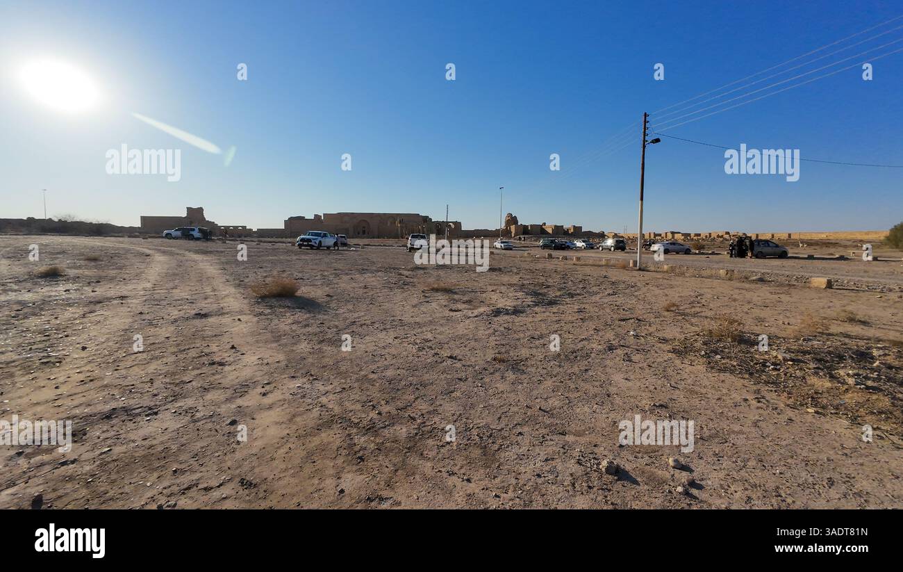 A barren desert landscape with scattered vehicles and a distant ...