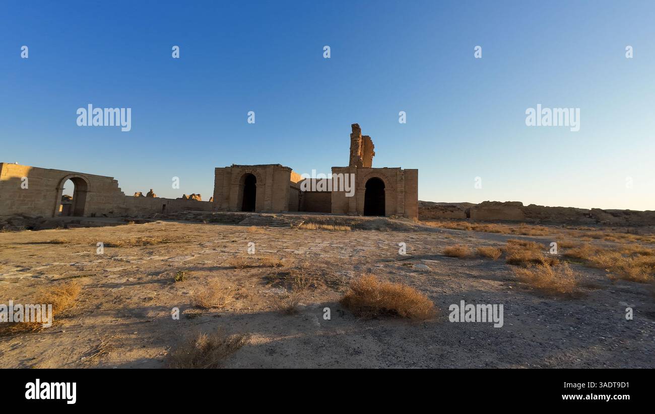 Ruins of an ancient stone structure in a desert landscape under a clear ...