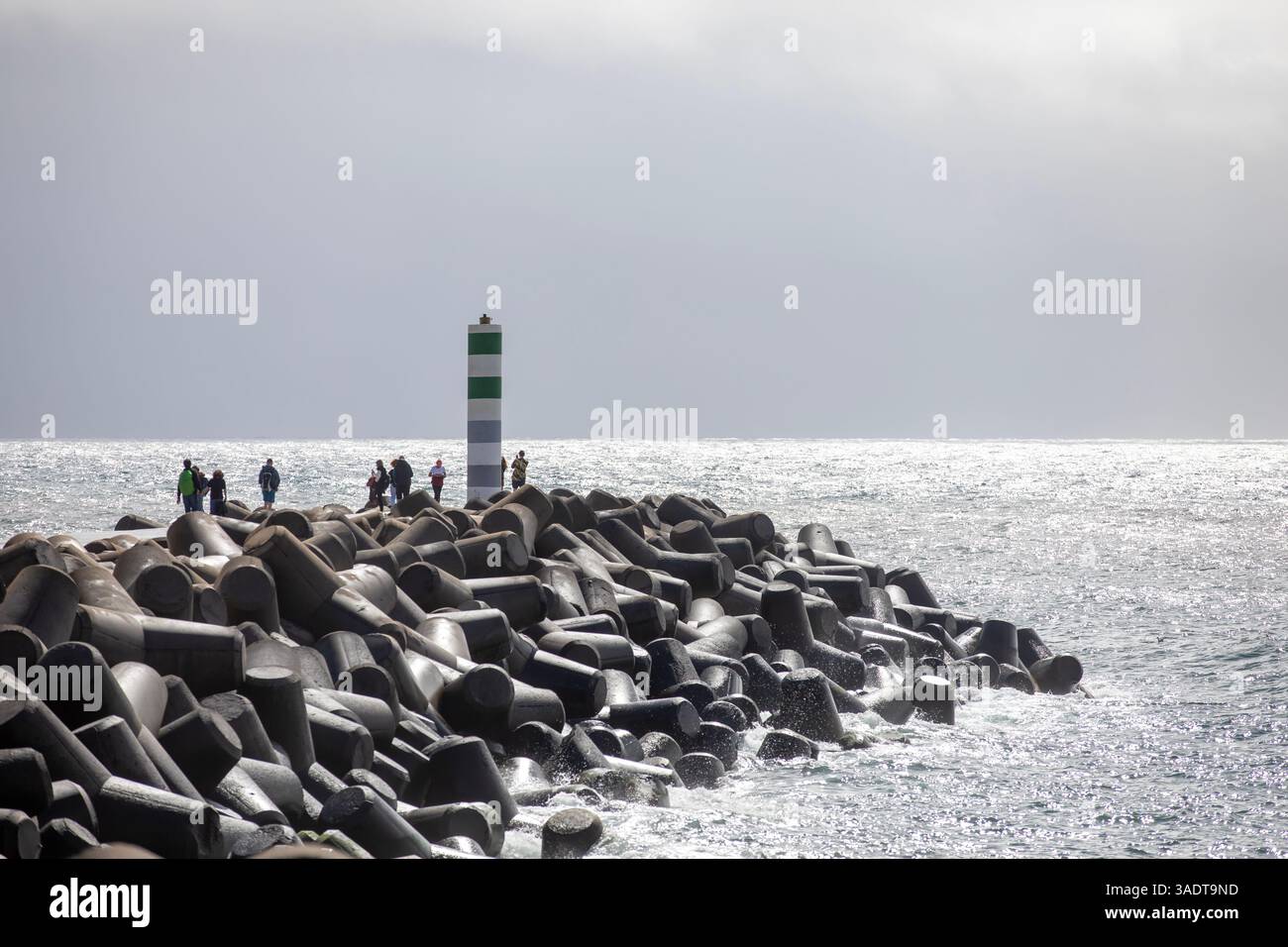 Jetty and breakwater with lighthouse on beach in Funchal Madeira Stock ...