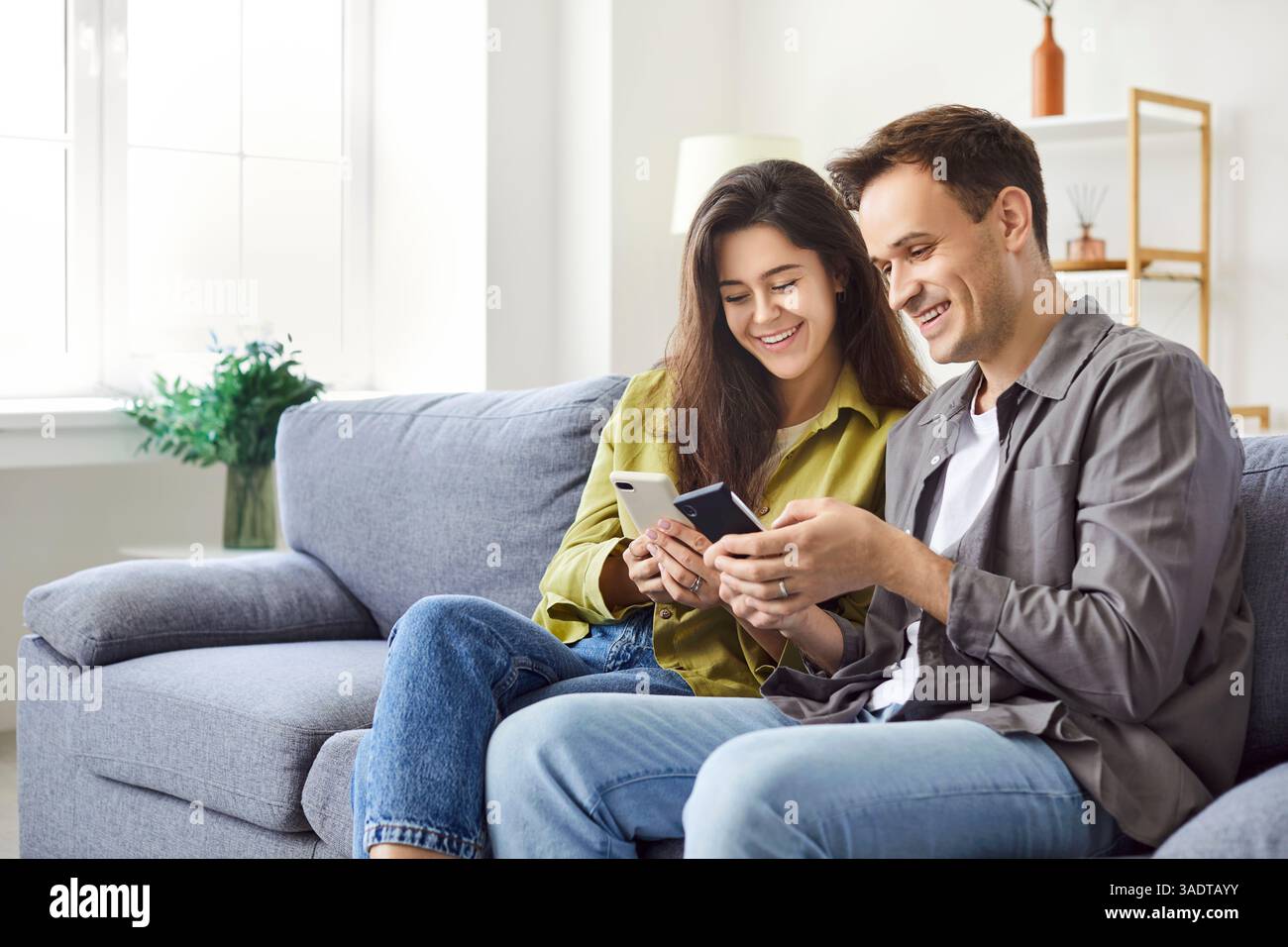 Happy family couple using their smartphones to show each other ...
