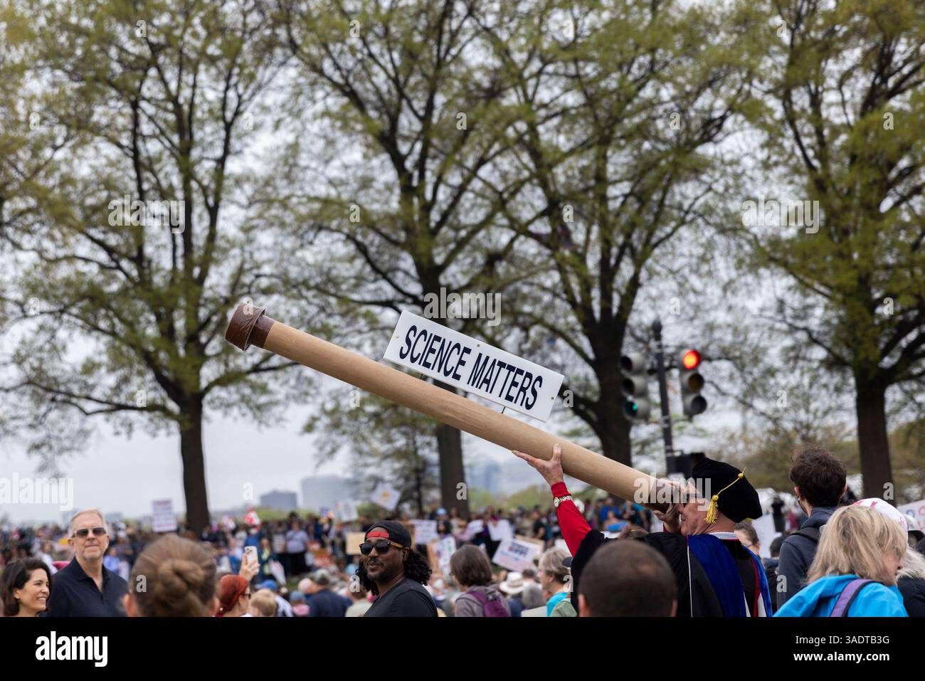 A person holds a sign while protestors demonstrate at a 'Hands Off ...