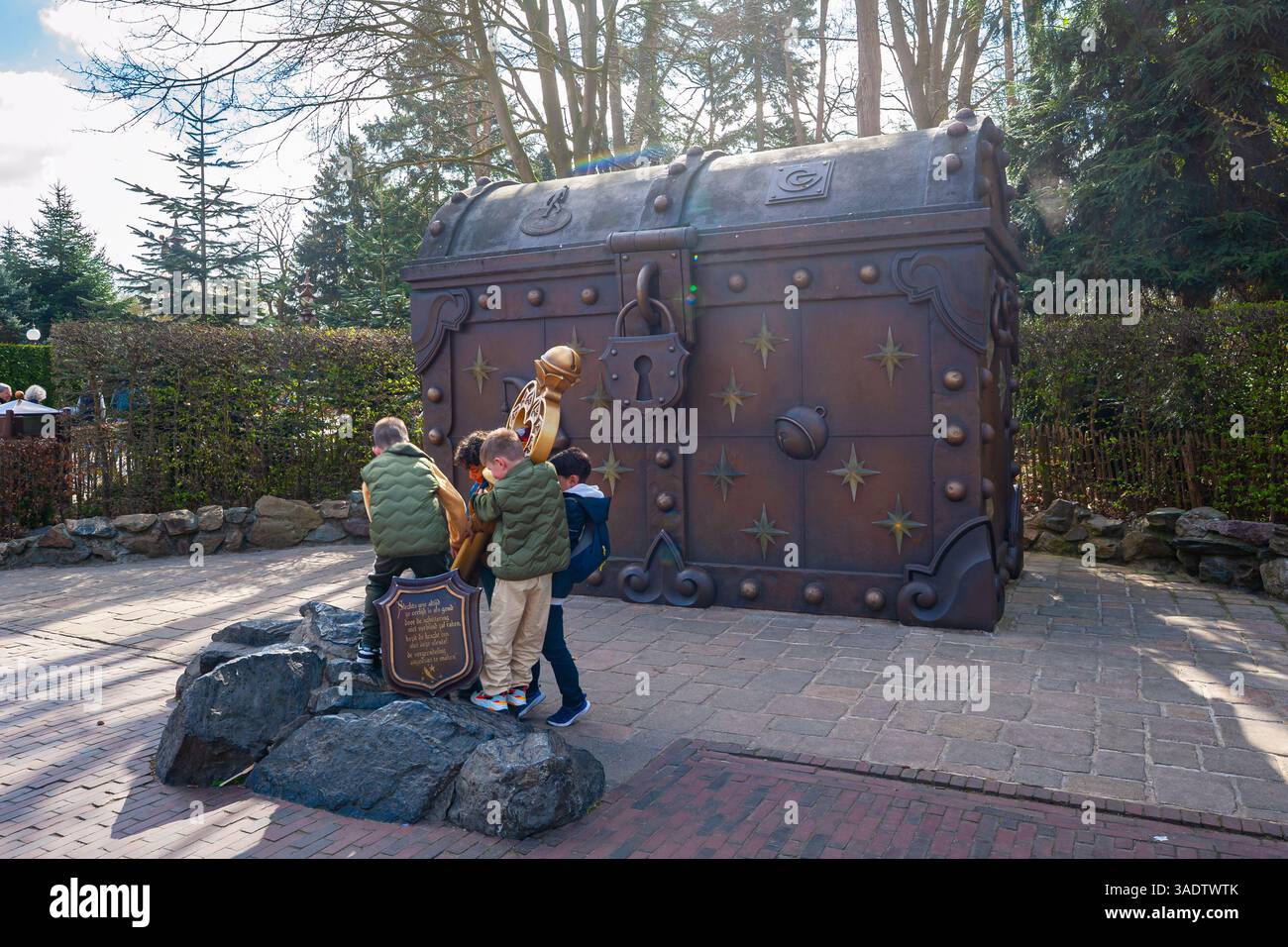 Children try to pull a huge golden key out of a rock to open the even ...