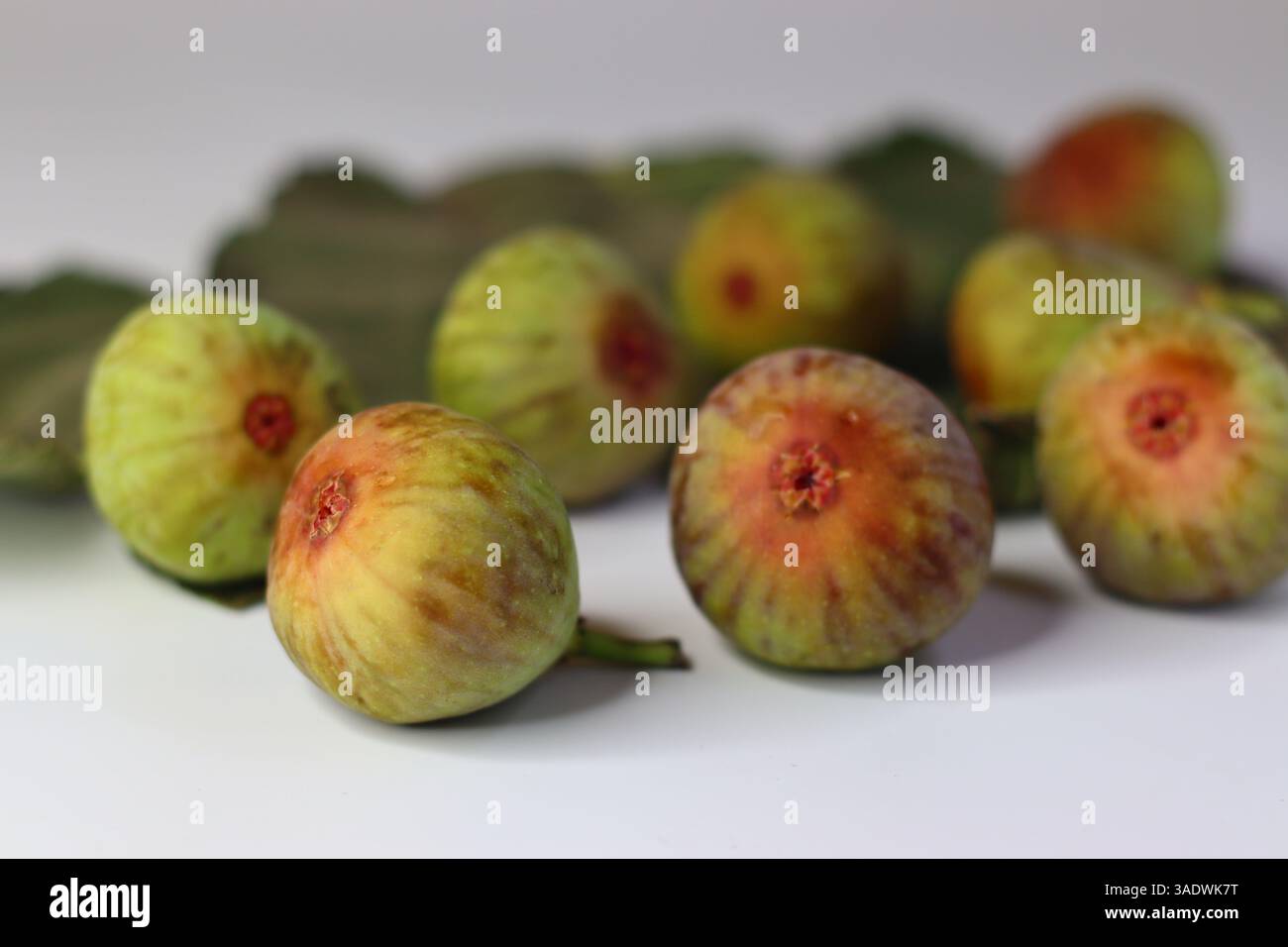 Fresh figs with green leaves on a white background Stock Photo - Alamy