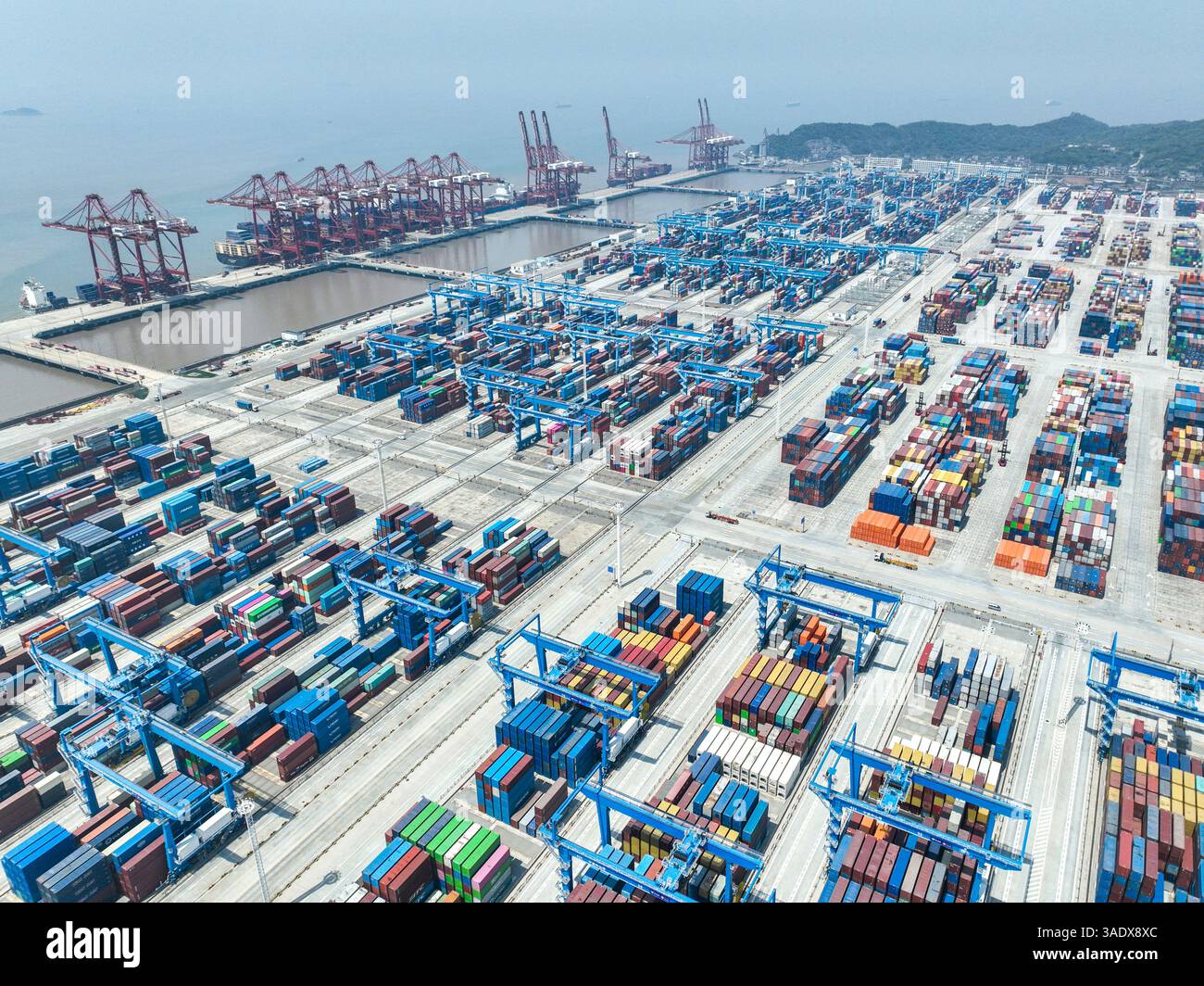 Driverless trucks transfer containers at the Dapukou container terminal ...