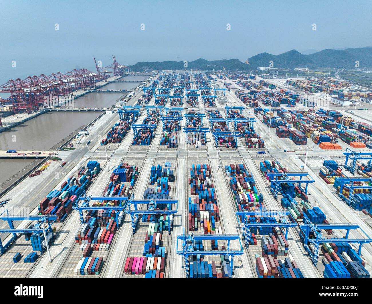 Driverless trucks transfer containers at the Dapukou container terminal ...