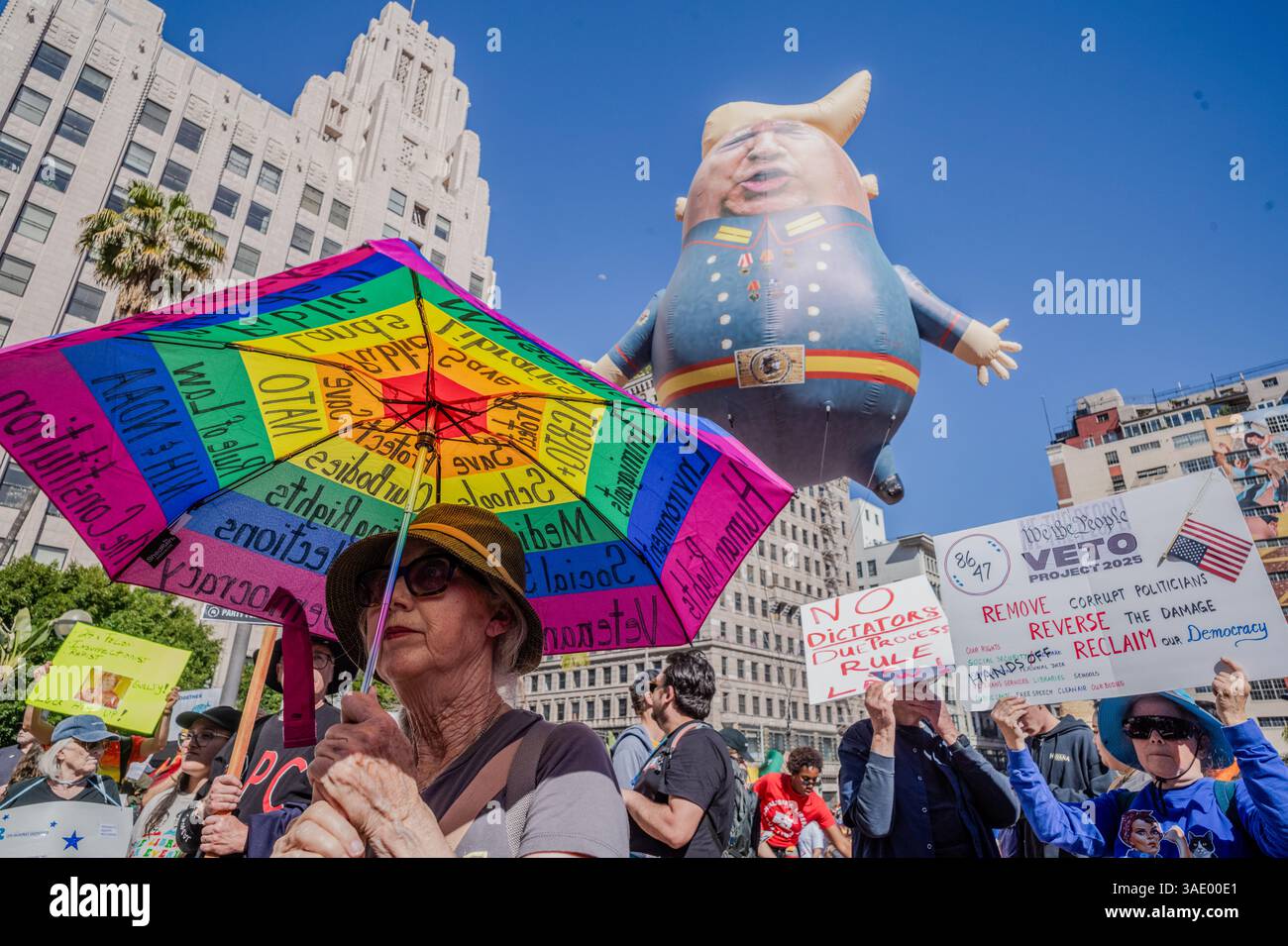 A protester holds an umbrella in a march and protest of President Trump ...