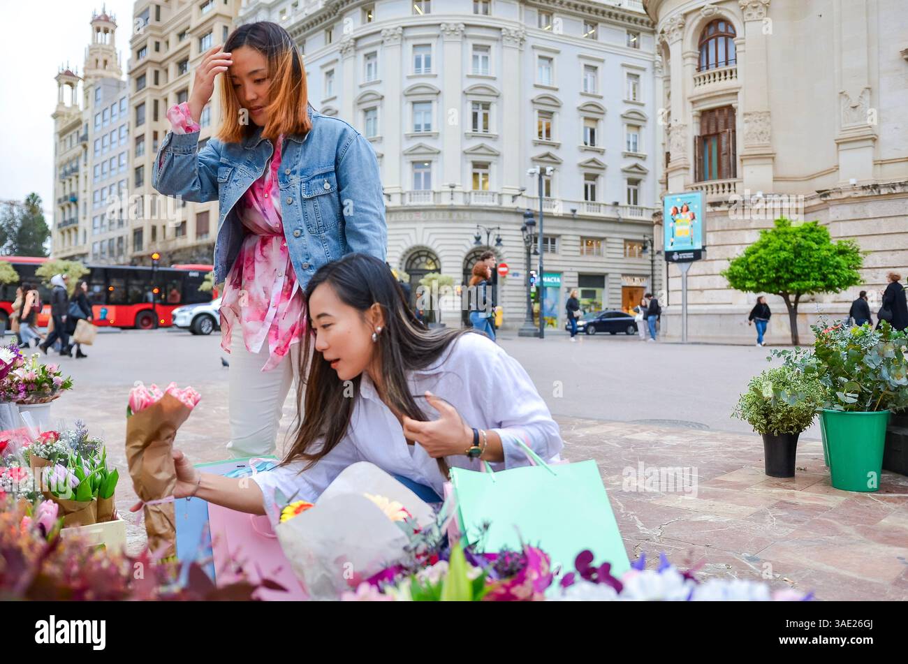 Two friends are selecting a bouquet of flowers at an outdoor flower ...