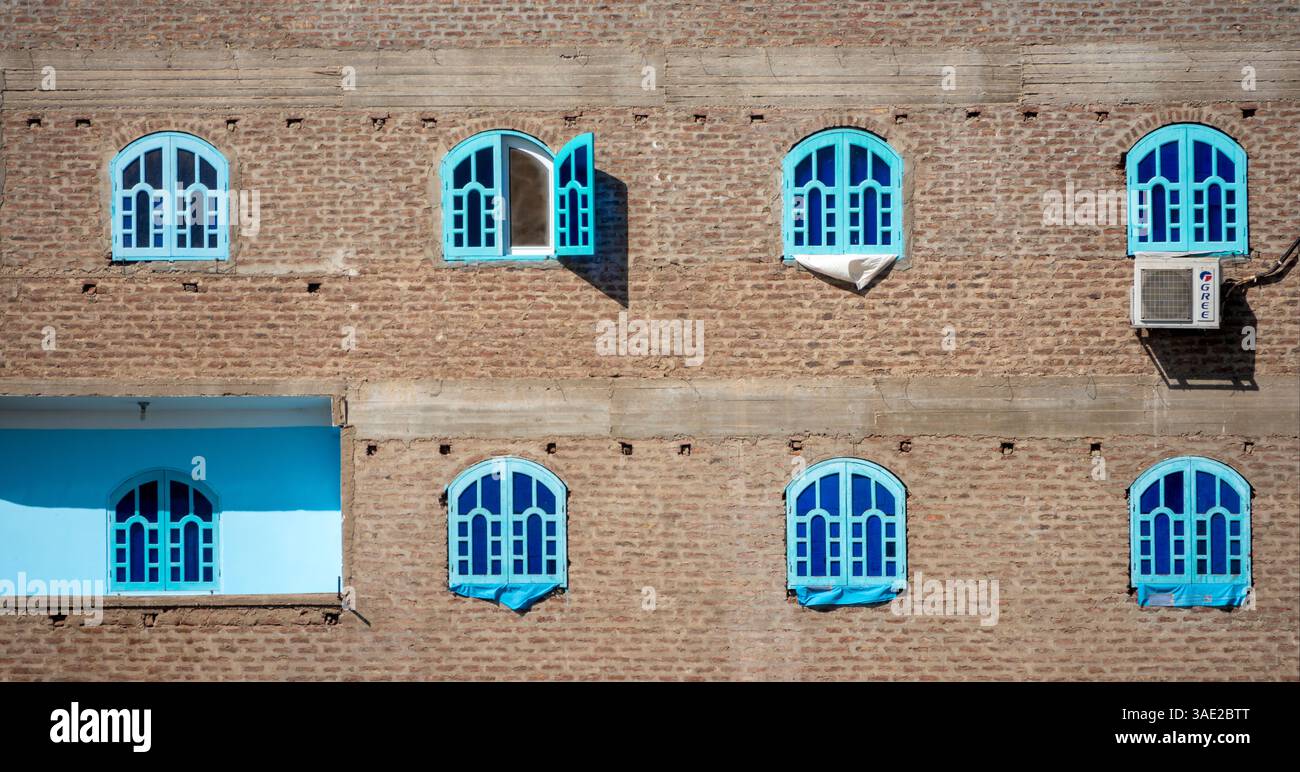 Side elevation of a grey brick and concrete apartment block with eight ...