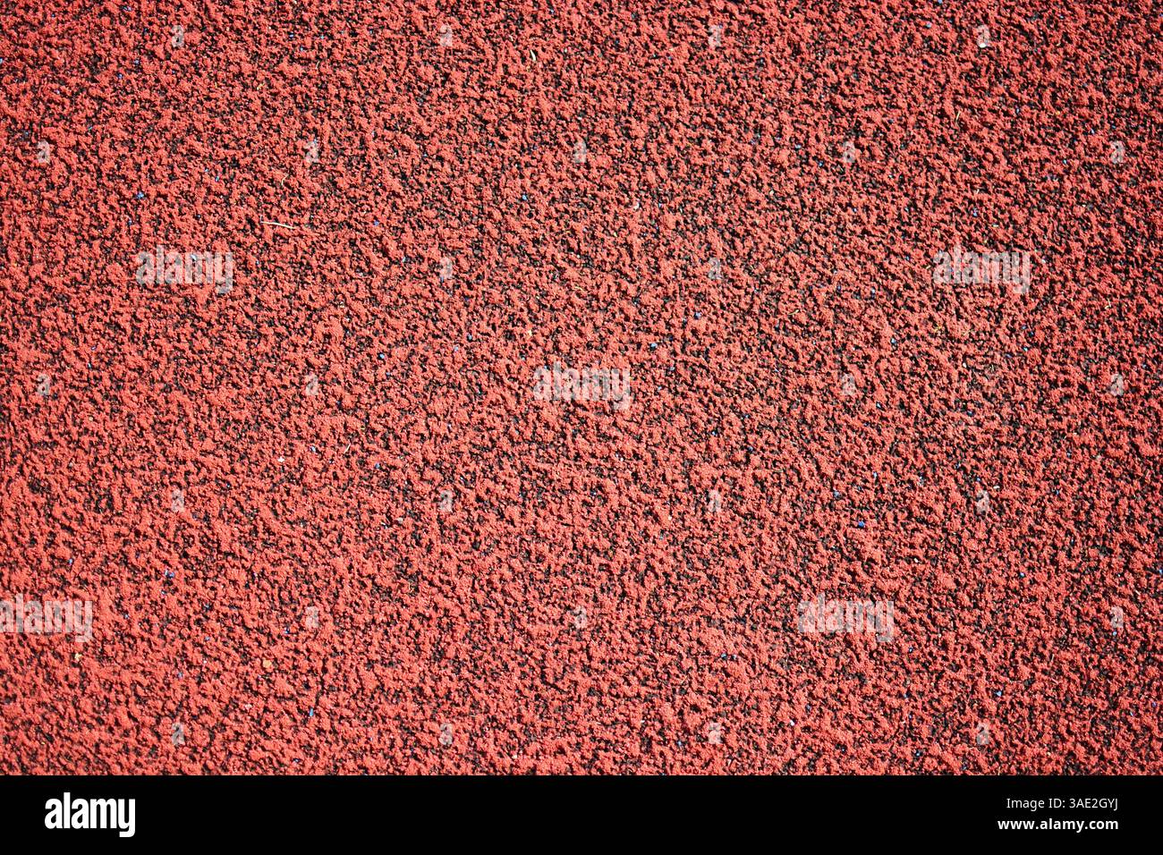 Red sports field rubber coating close up macro view. Playground paving ...
