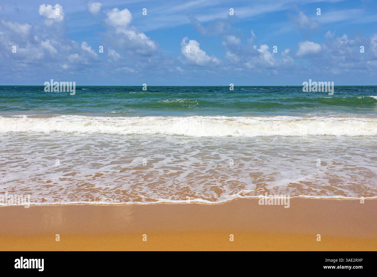Empty sea beach with yellow sand, view to emerald green waves and blue ...