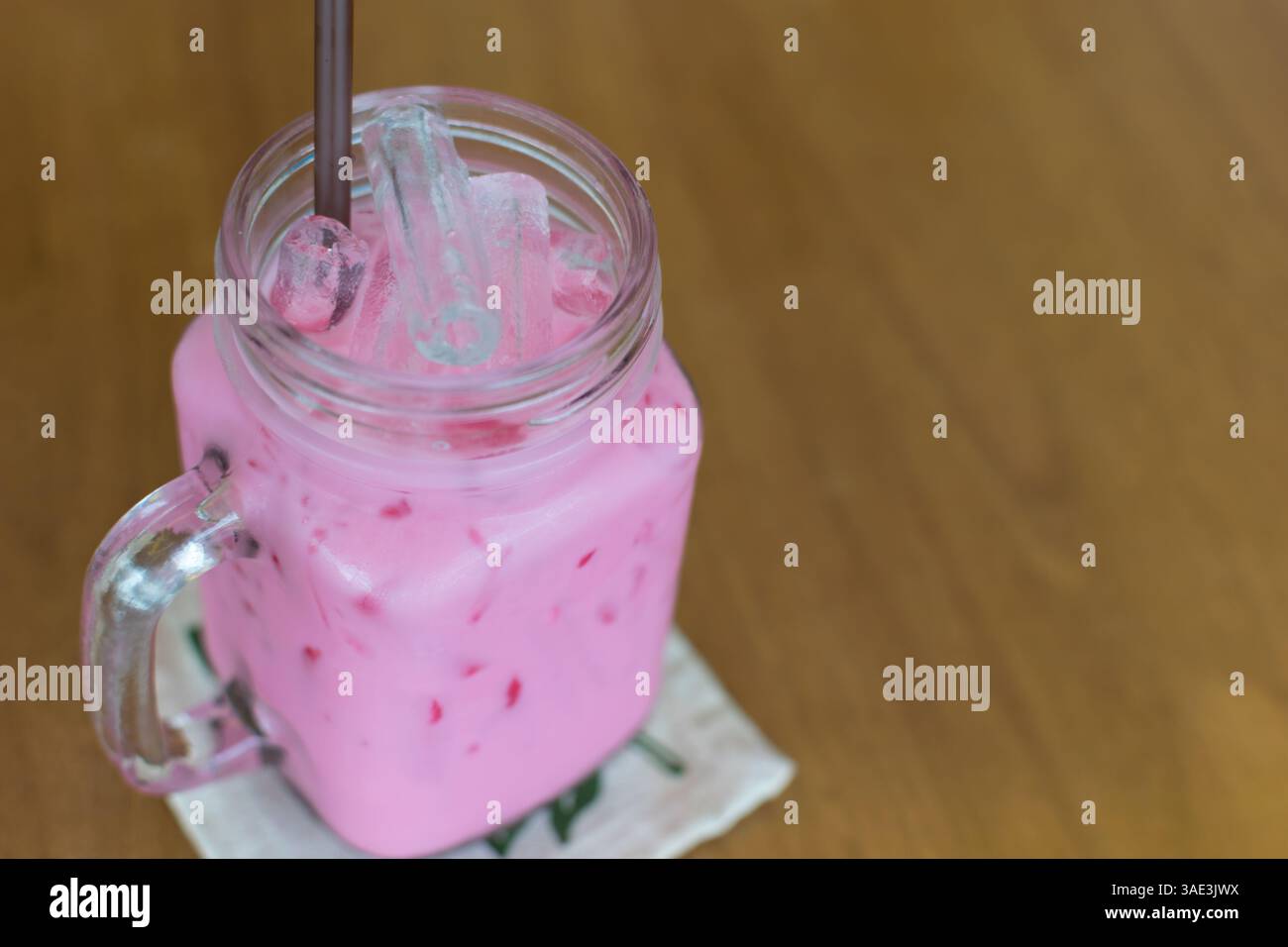 Milk pink sweet cold drink in glass on a wood table Stock Photo - Alamy