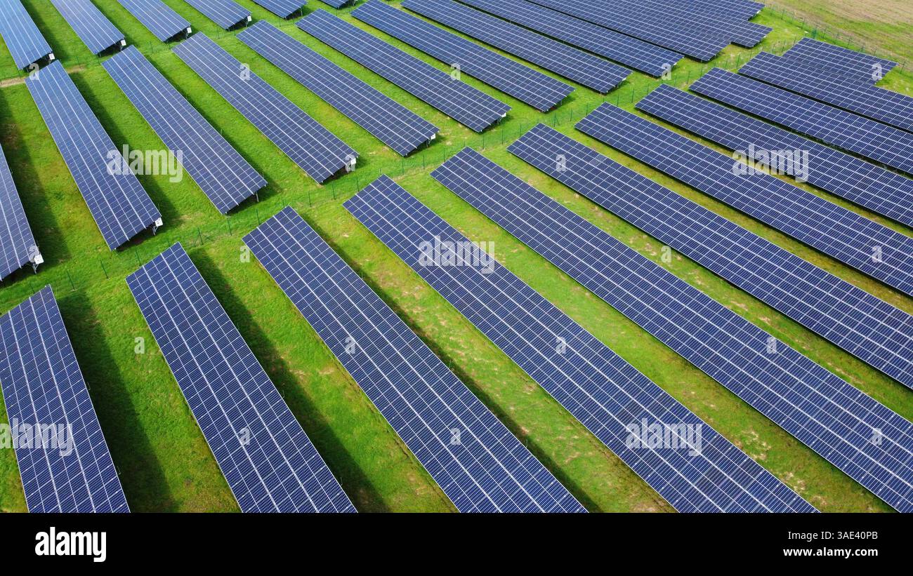 A large solar power plant farm with multiple rows of photovoltaic ...