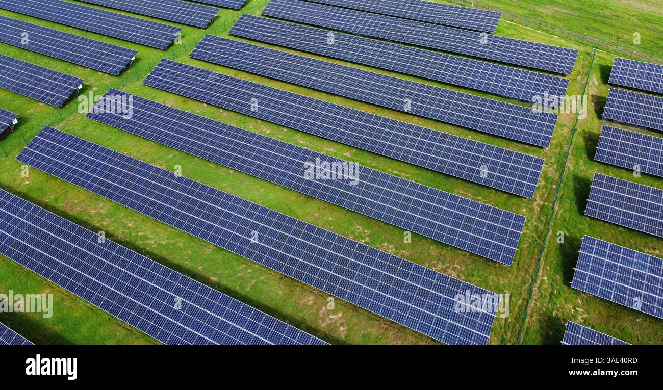 A large solar power plant farm with multiple rows of photovoltaic ...