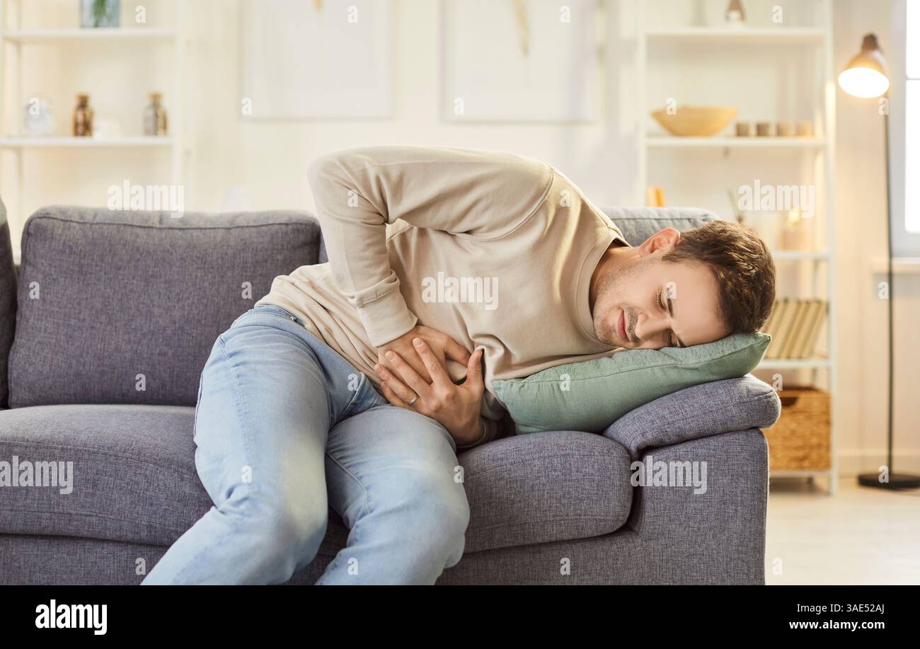 Sick man on sofa, touching belly in bad suffer from stomach ache, ill ...