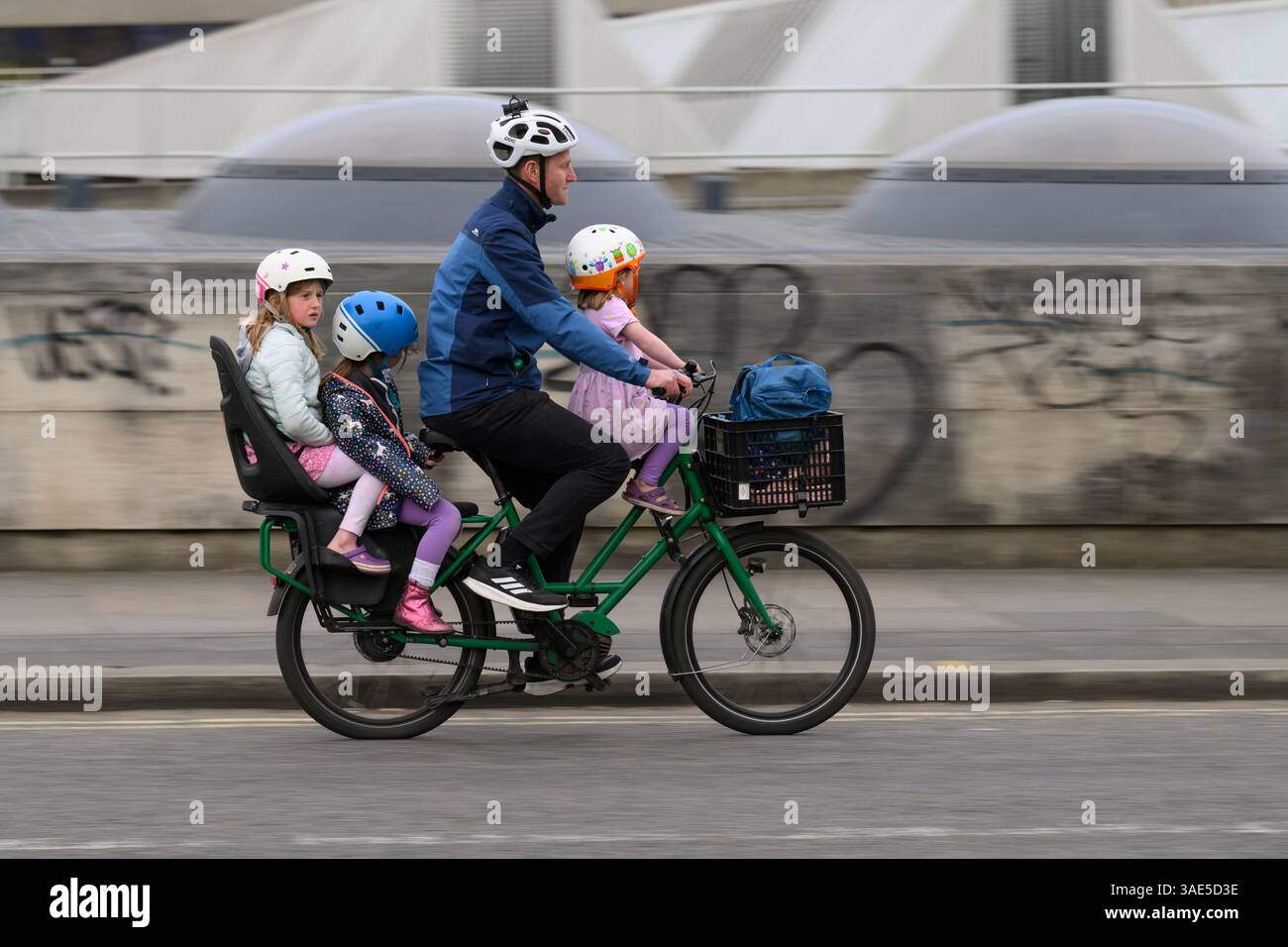 A man transports three small children on a Veloe Multi Bosch Cargoline ...