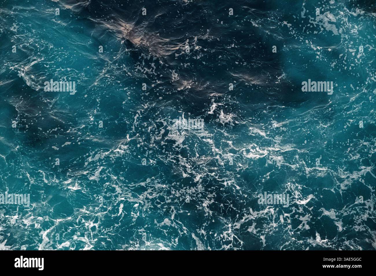 A captivating top-down view of ocean waves, blending light and shadow ...