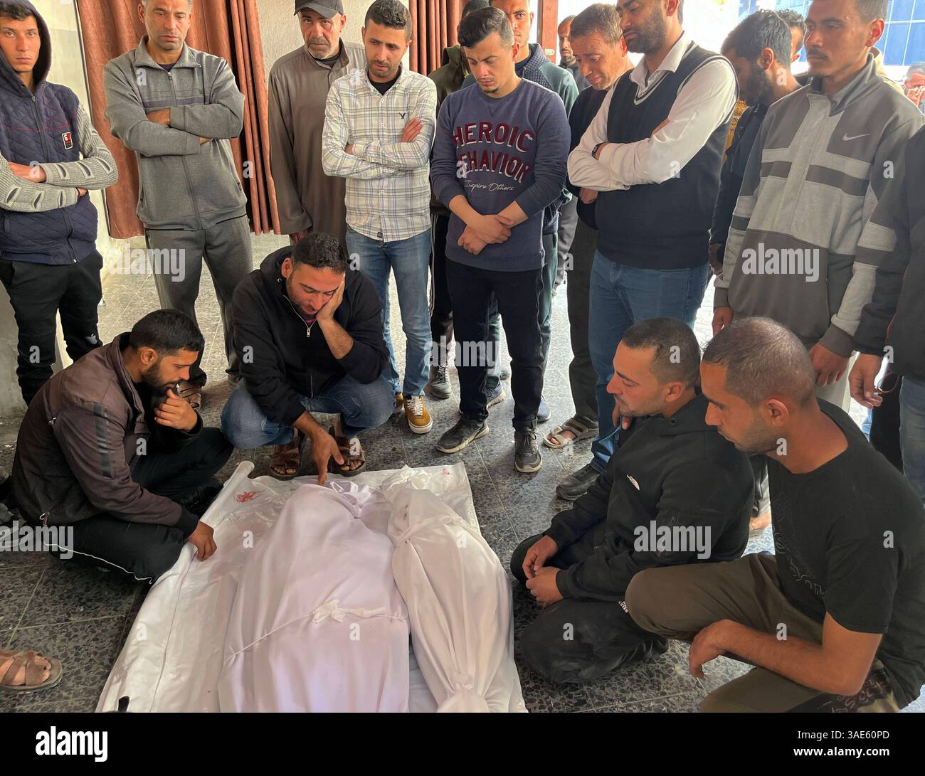 Palestinians mourn over the bodies of loved ones killed in overnight ...