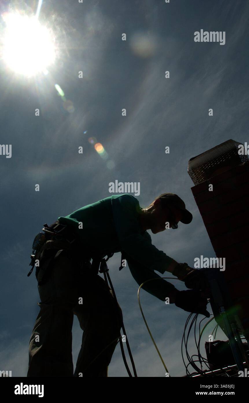 SolarCity's lead solar installer Kevin Ruszel works on the cables that ...