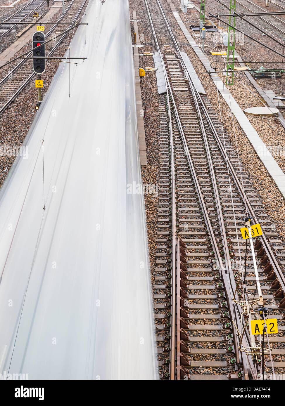 A high-speed train glides past on multiple railway tracks, emphasizing ...