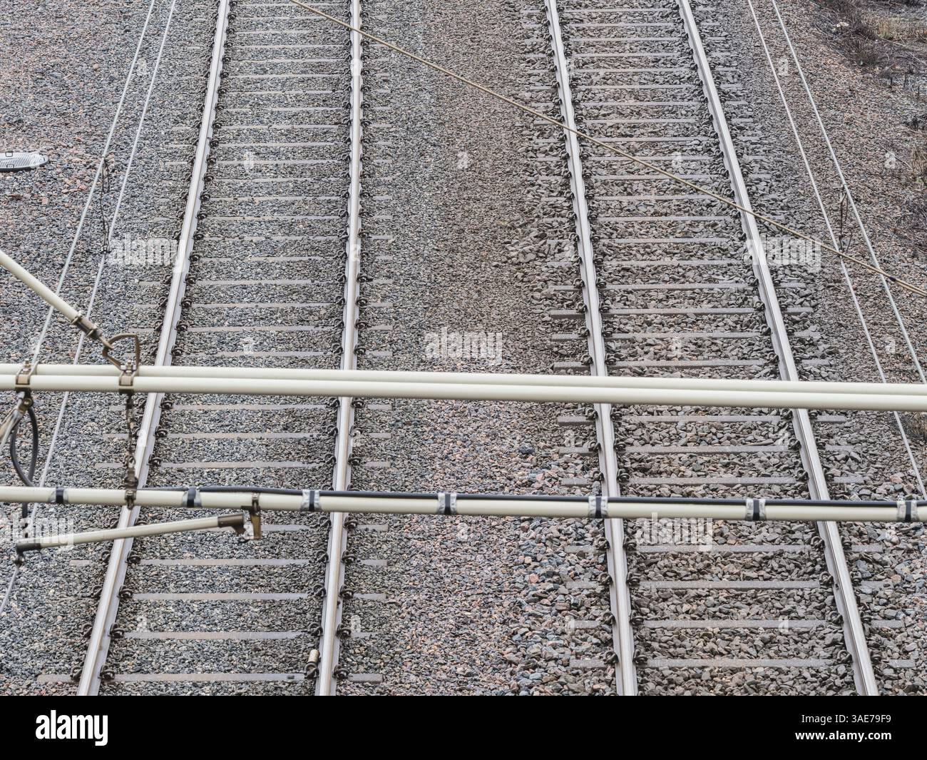 Steel tracks run parallel across gravel, indicating the railway system ...