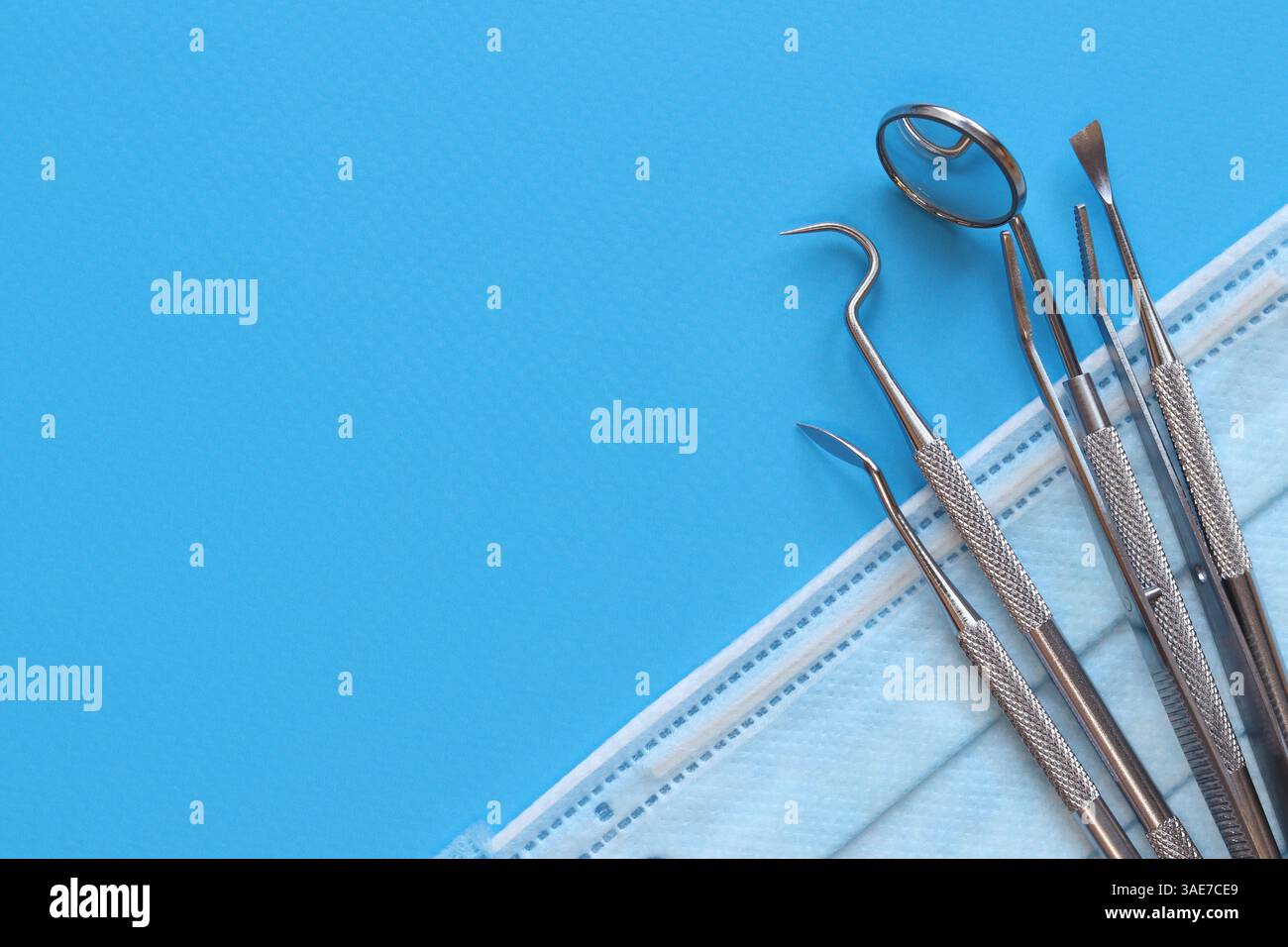 Dental mirror, tweezers and several hooks on disposable medical mask ...