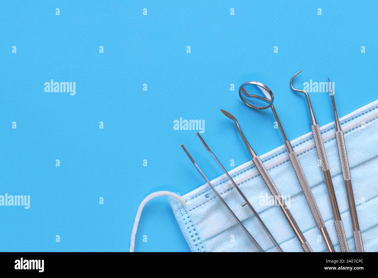 Dental mirror, tweezers and several hooks on disposable medical mask ...