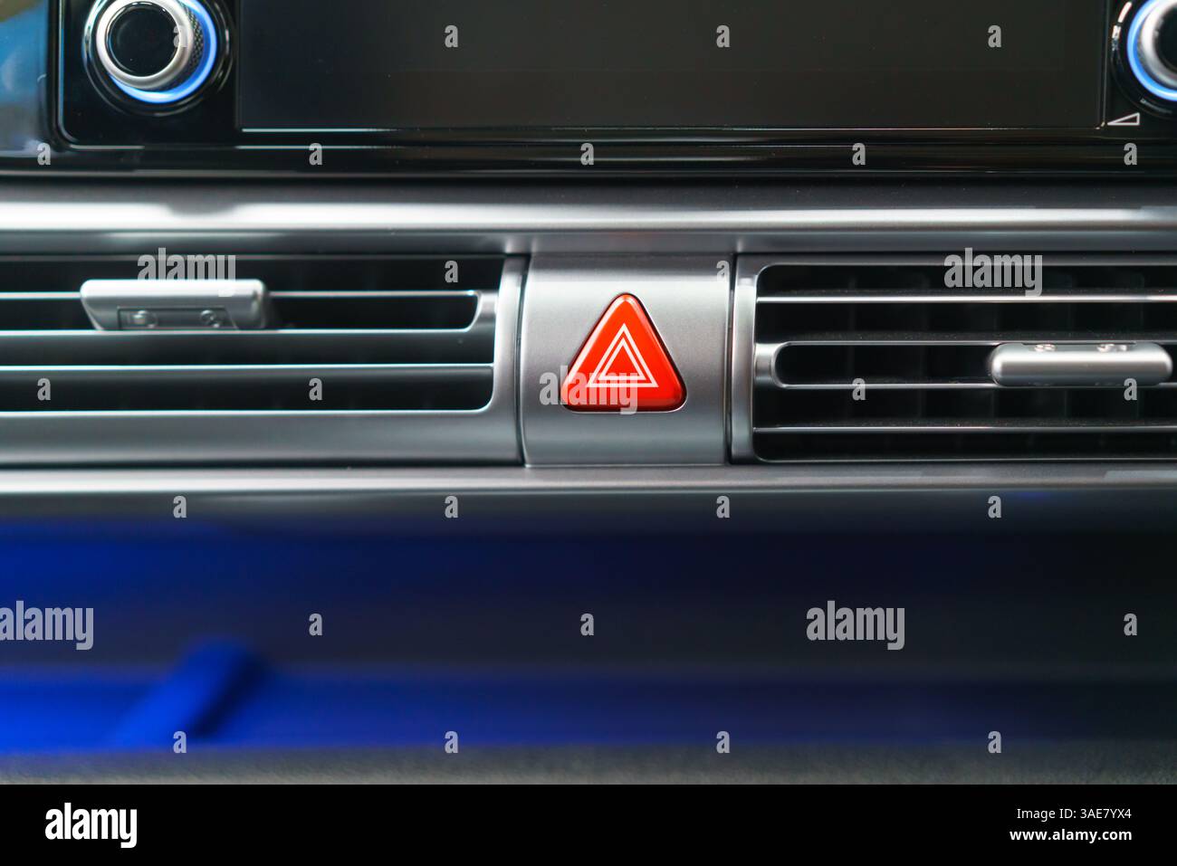 Close-up of a hazard warning button on a car's dashboard vent ...