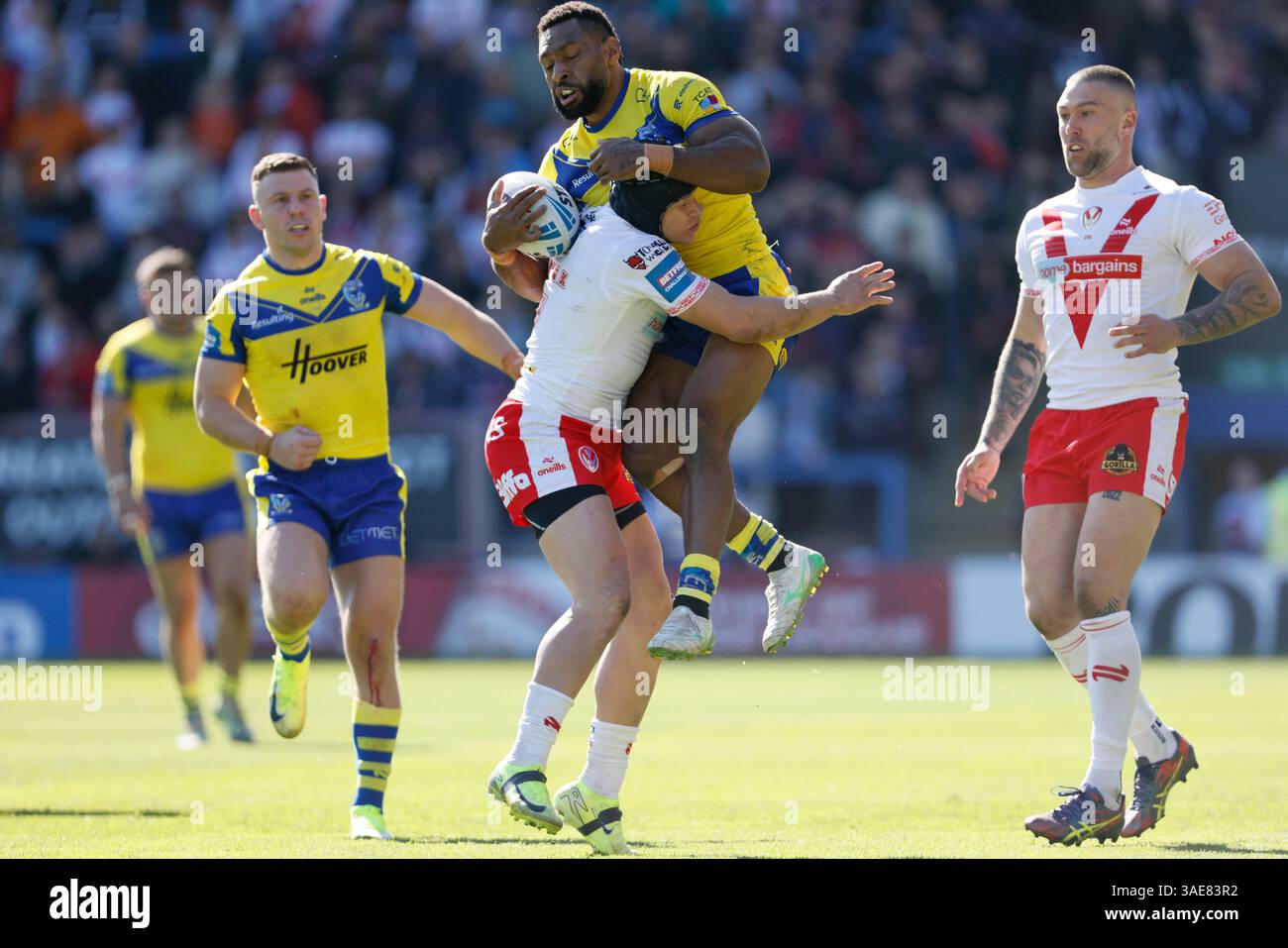 St Helens' Jonny Lomax (left) tackles Warrington Wolves' Rodrick Tai ...