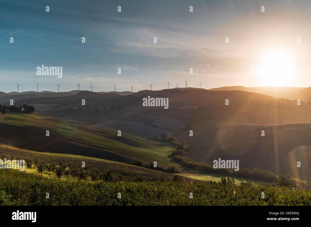 Wind turbines on top of the rolling hills of the Tuscan countryside ...