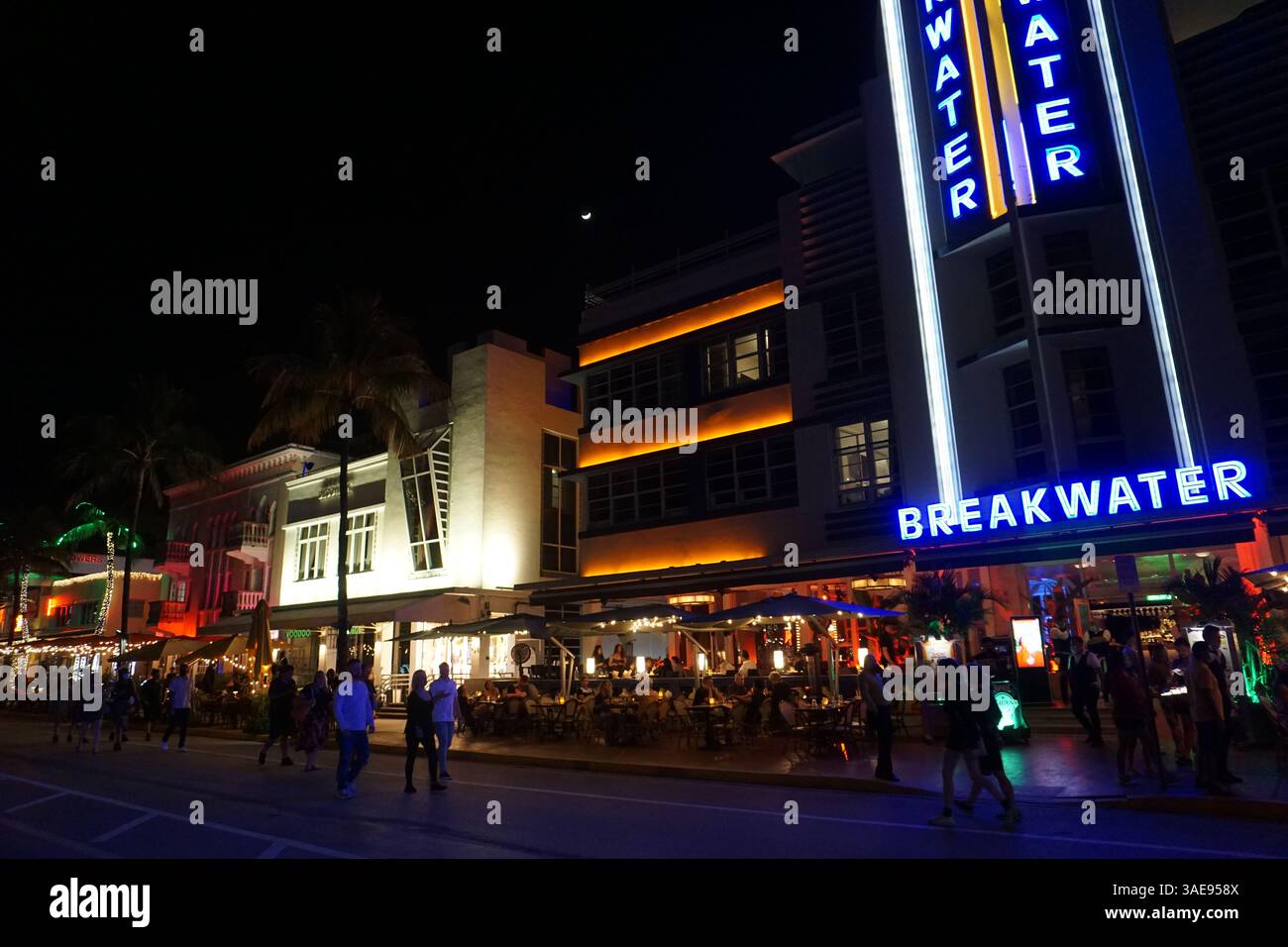 The colorful neon sign of the Breakwater hotel illuminates a busy ...