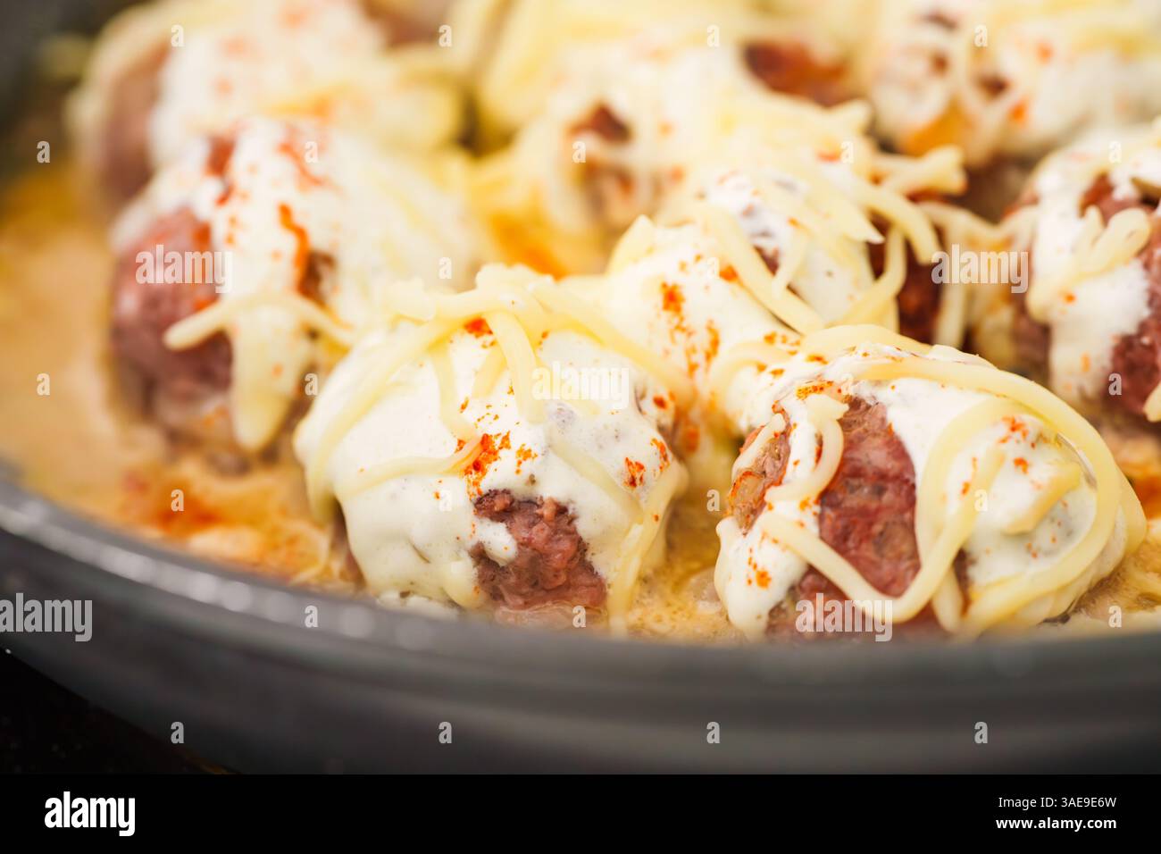 Cheesy meatballs bubbling in a rich white sauce Stock Photo - Alamy