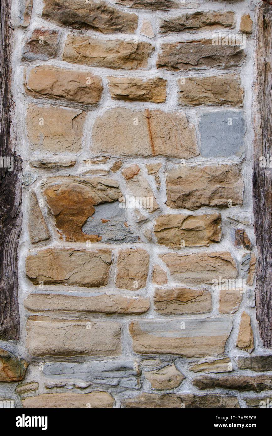 This close-up view reveals a weathered stone wall with a mix of earthy ...