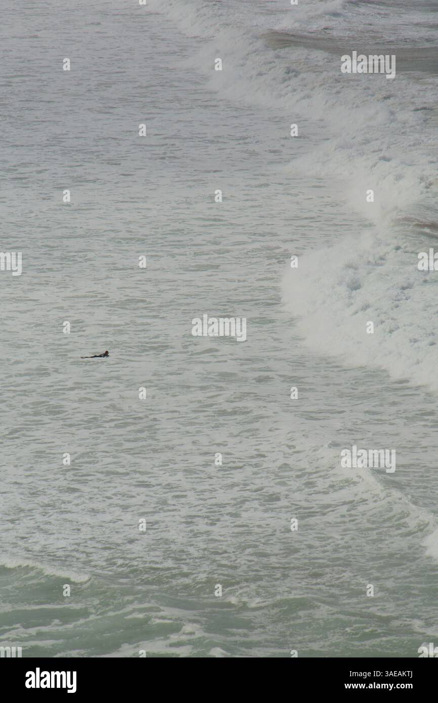 single surfer going out in big white surf Stock Photo - Alamy