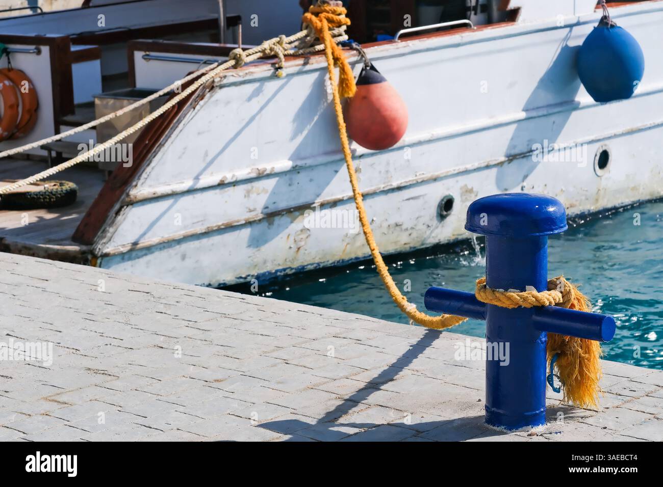A blue and yellow buoy is tied to a boat. The buoy is attached to a ...