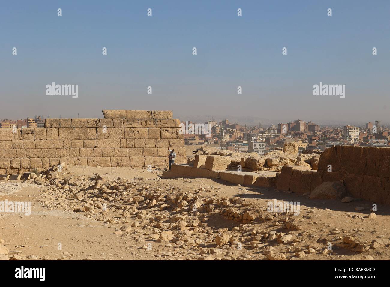 Stone remains of ancient Egyptian temples and a man admiring their ...